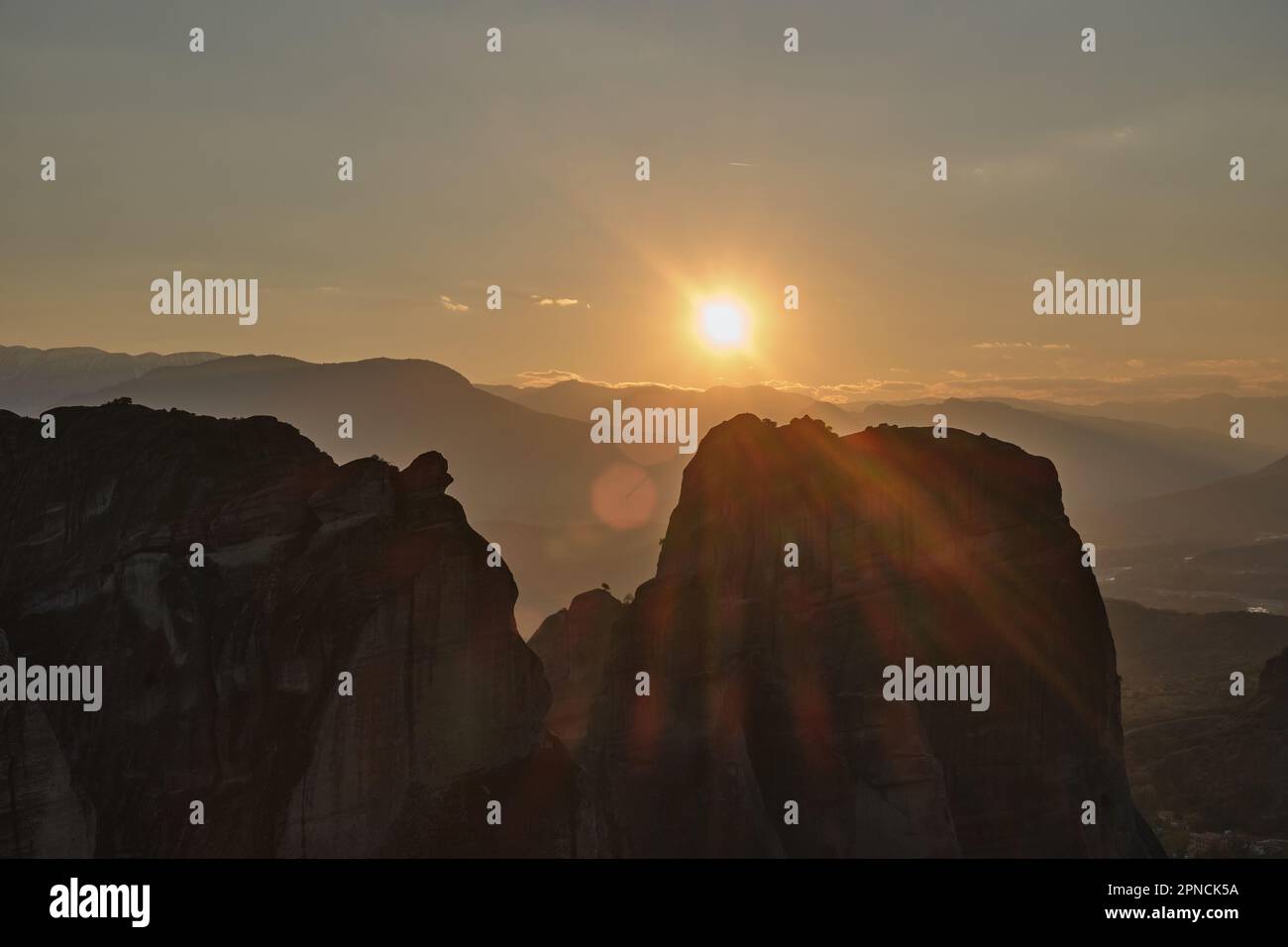 Sun flare at sunset over Meteora in Spring Stock Photo - Alamy