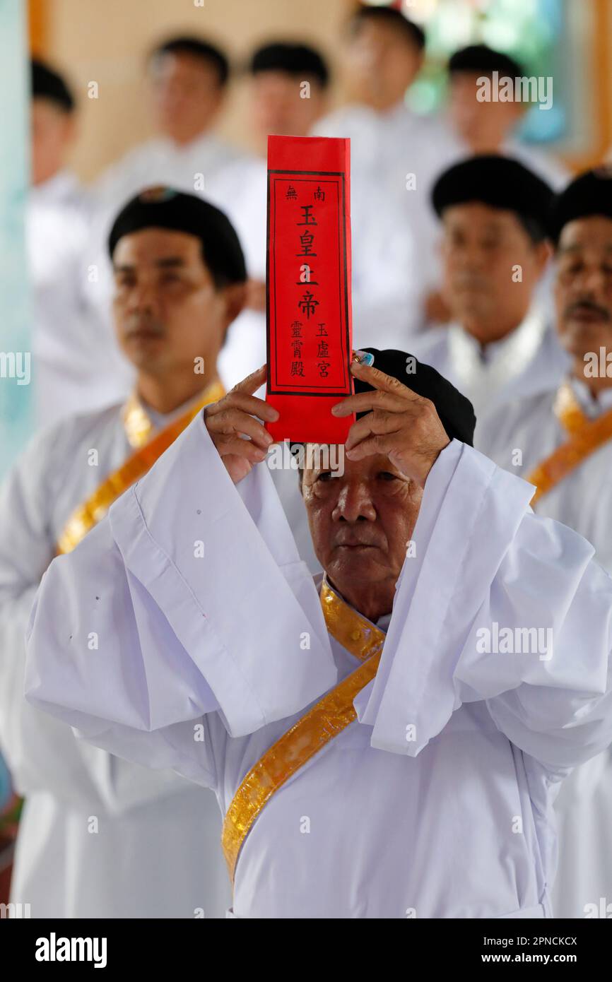Cao Dai temple. Caodaist worshippers at ceremony. Meditating followers ...