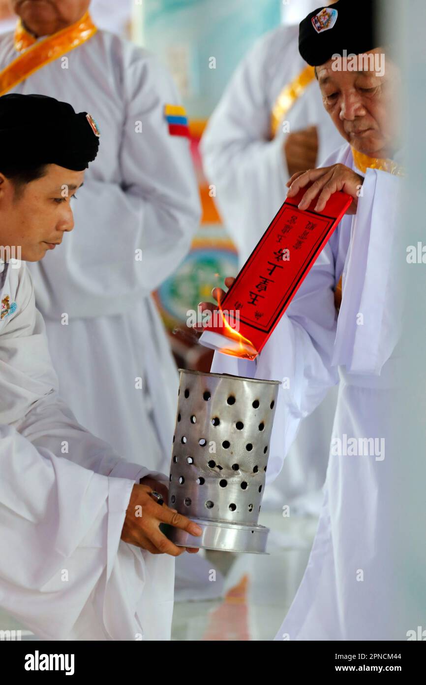 Cao Dai temple. Caodaist worshippers at ceremony. Meditating followers ...