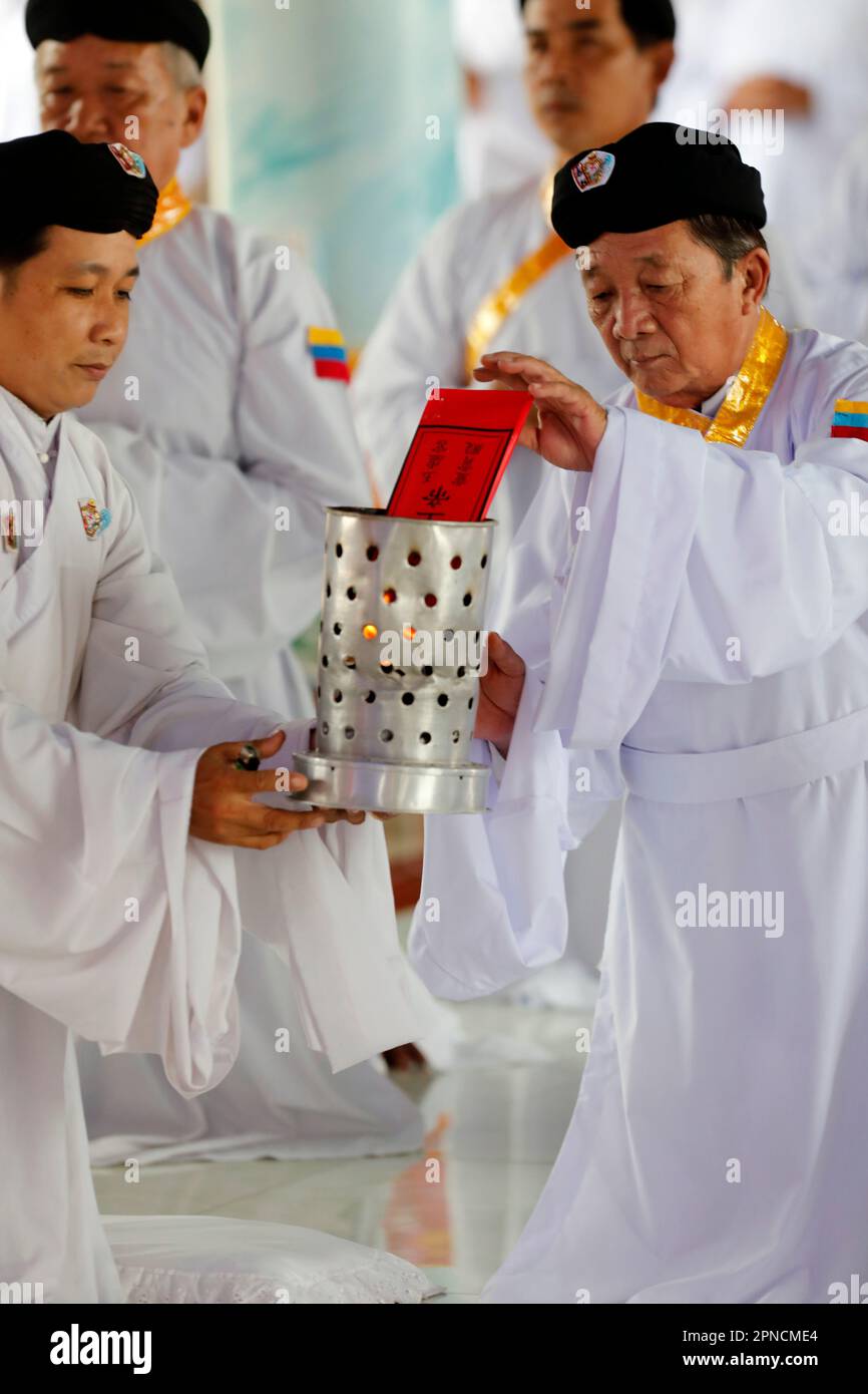 Cao Dai temple. Caodaist worshippers at ceremony. Meditating followers ...