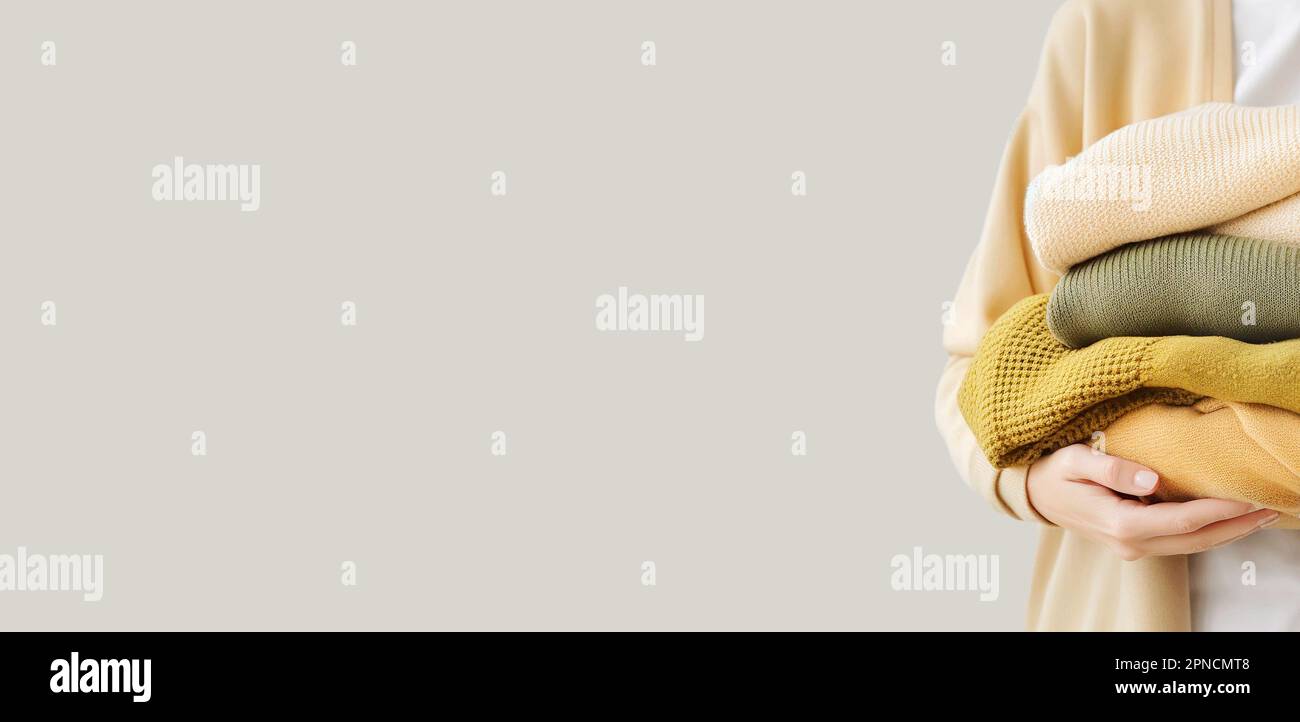 Woman's hand holding a stack of clothes. Clothes Donation, Renewable ...