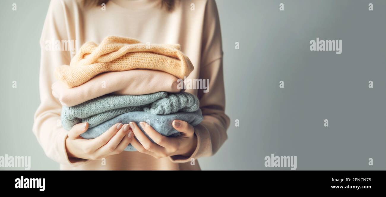 Woman's hand holding a stack of clothes. Clothes Donation, Renewable ...