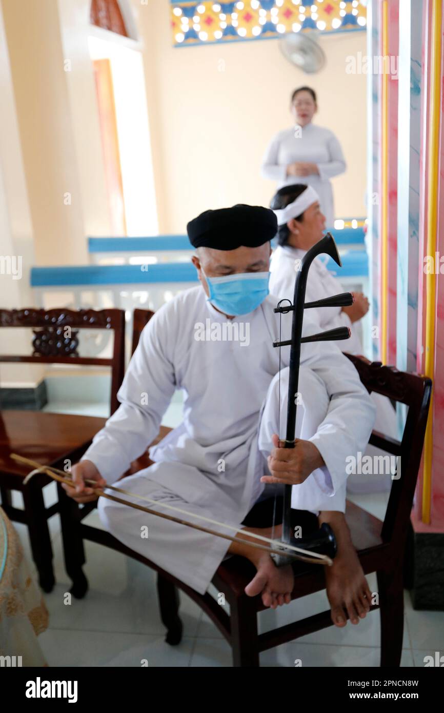 A Vietnamese man playing a Dan Nhi (Dan Co) a two stringed musical ...