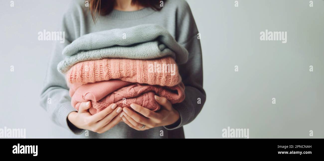 Woman's hand holding a stack of clothes. Clothes Donation, Renewable ...