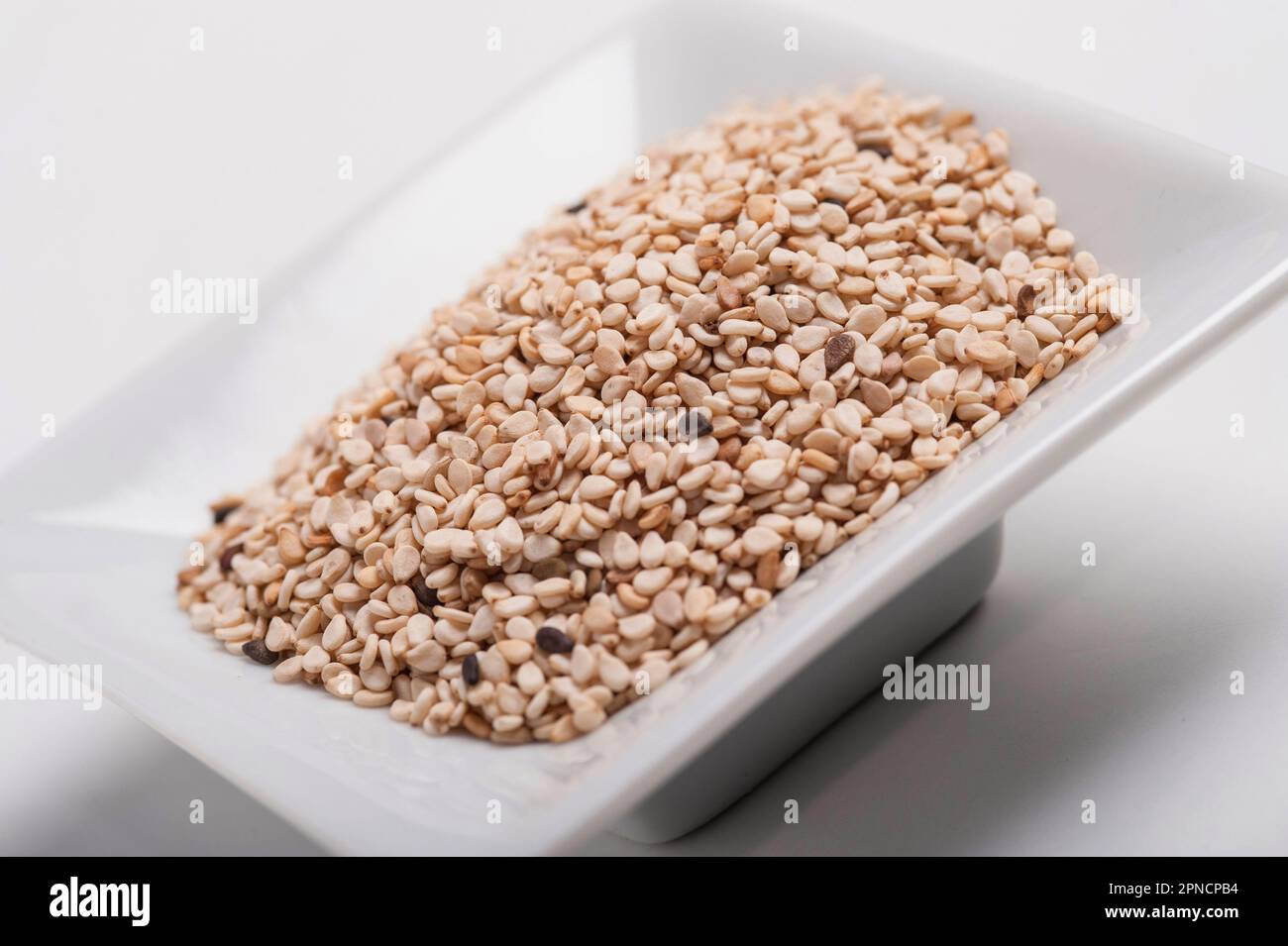 Sesame seeds on a white background Stock Photo - Alamy