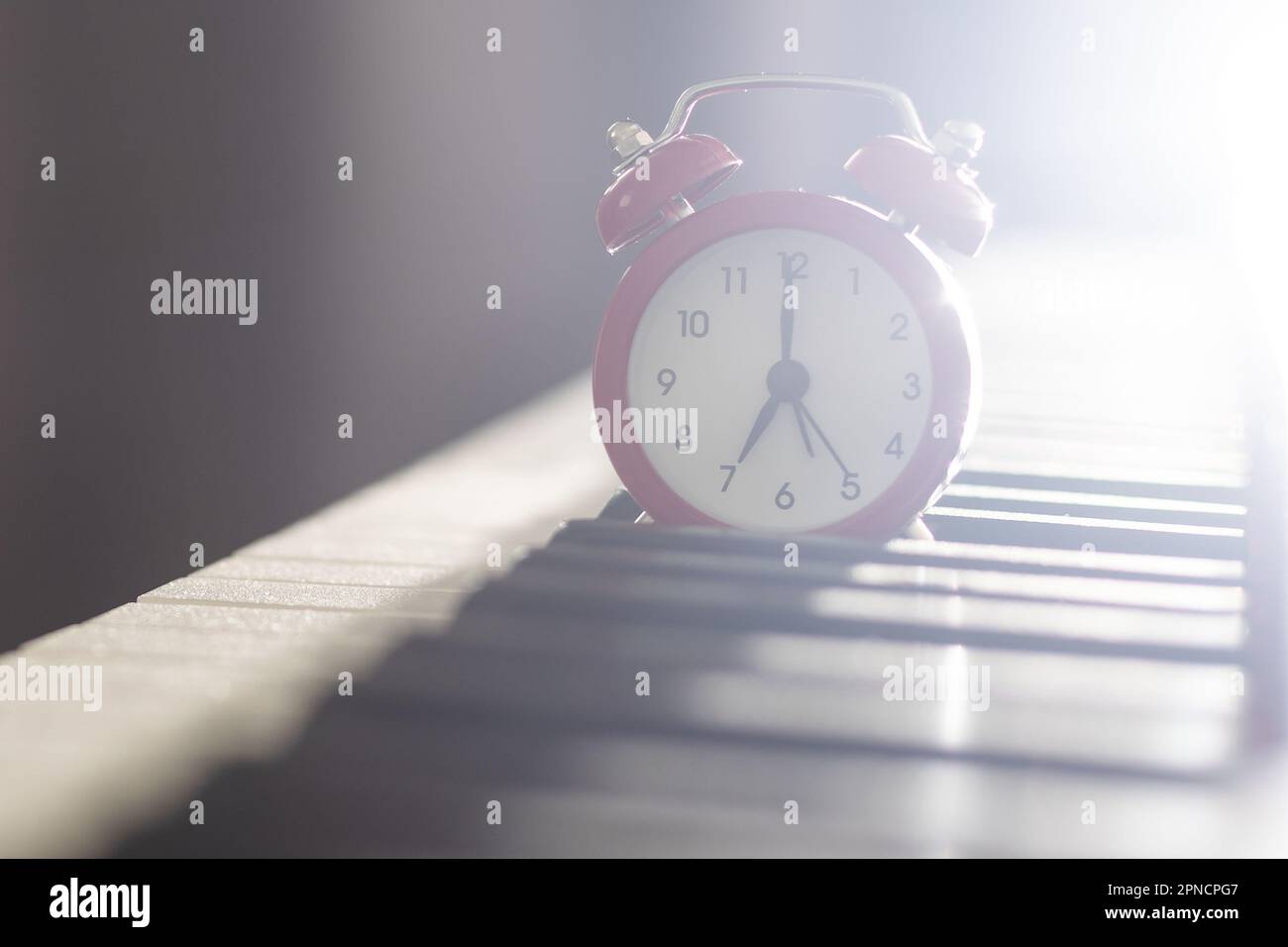 Alarm clock on piano background. Music lesson Stock Photo - Alamy