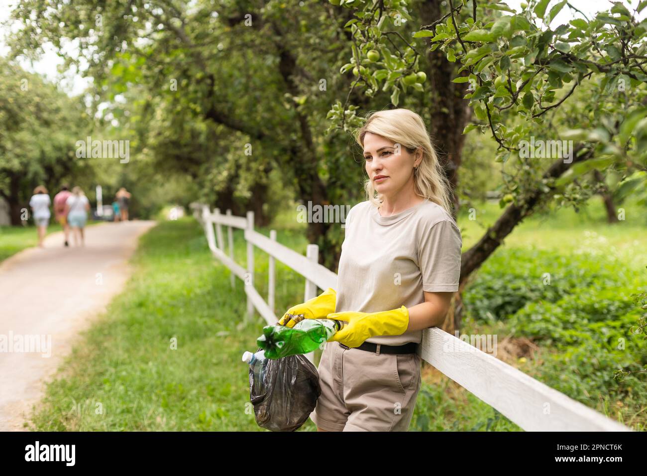 Volunteer woman keep plastic bottle into bag at public park ,Dispose ...