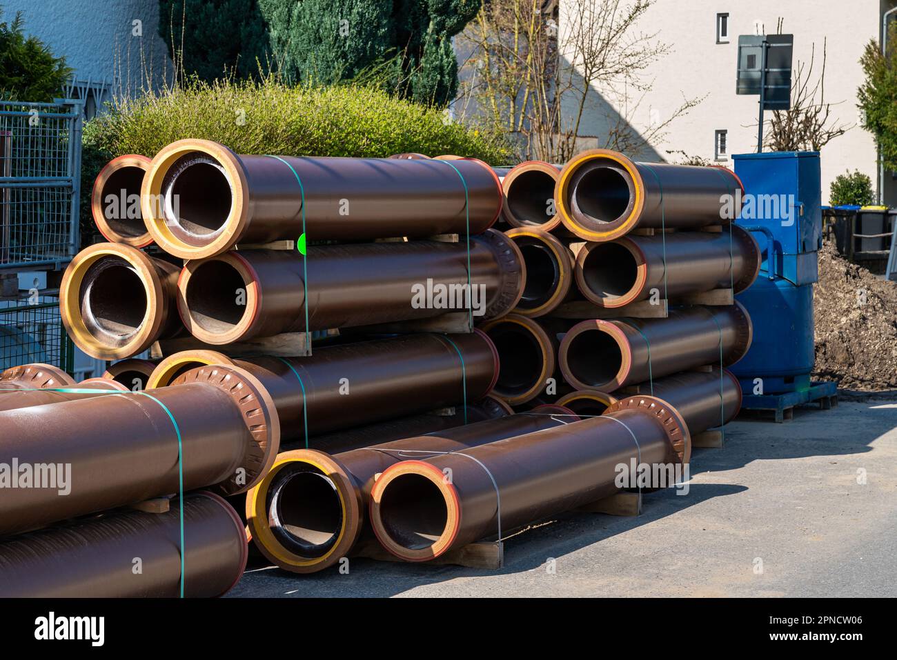 Brown ceramic pipes for laying water pipes are stacked on a ...