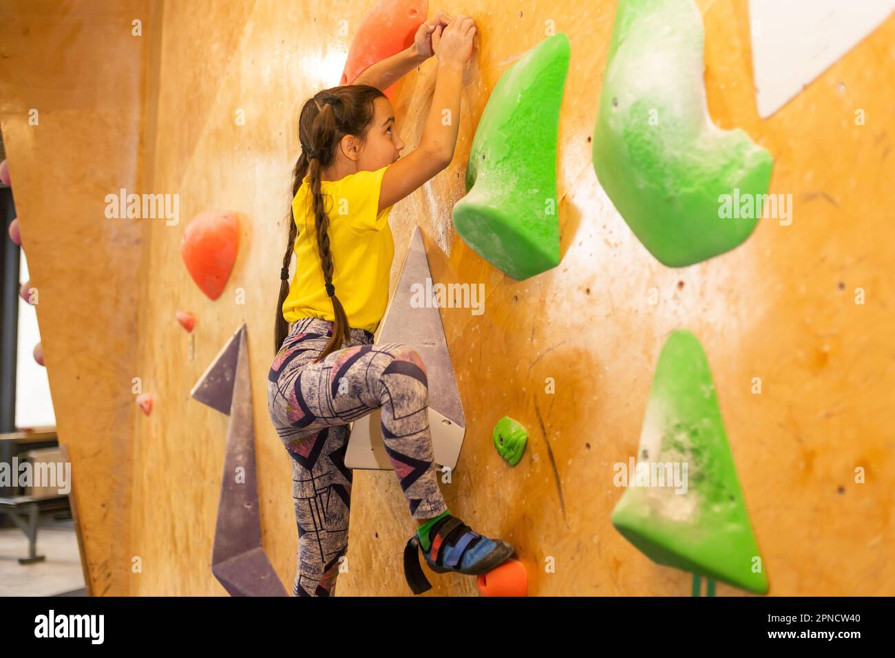 little girl climbing a rock wall indoor Stock Photo - Alamy