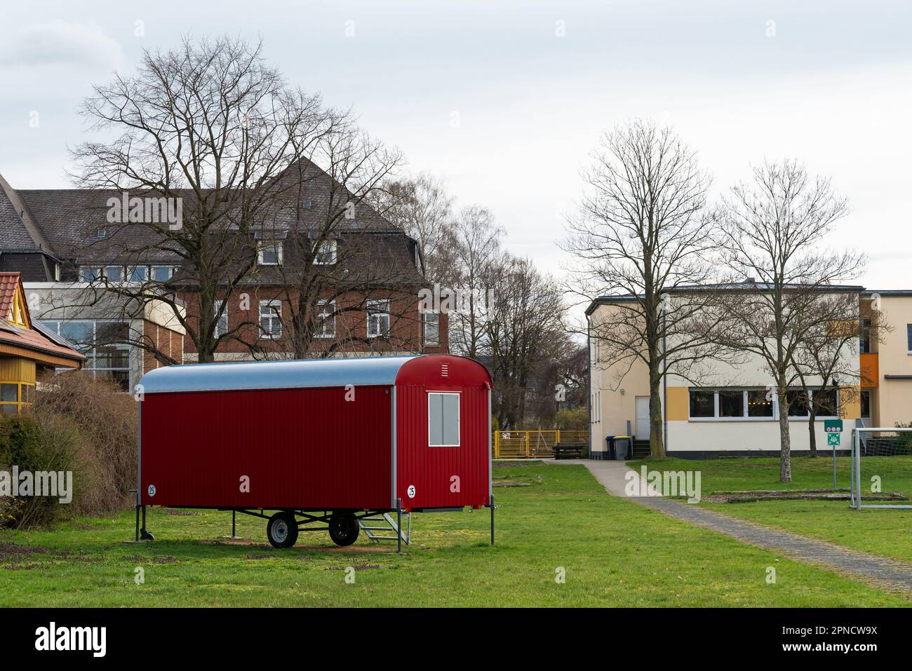A mobile residential trailer standing on a lawn in the middle of a ...