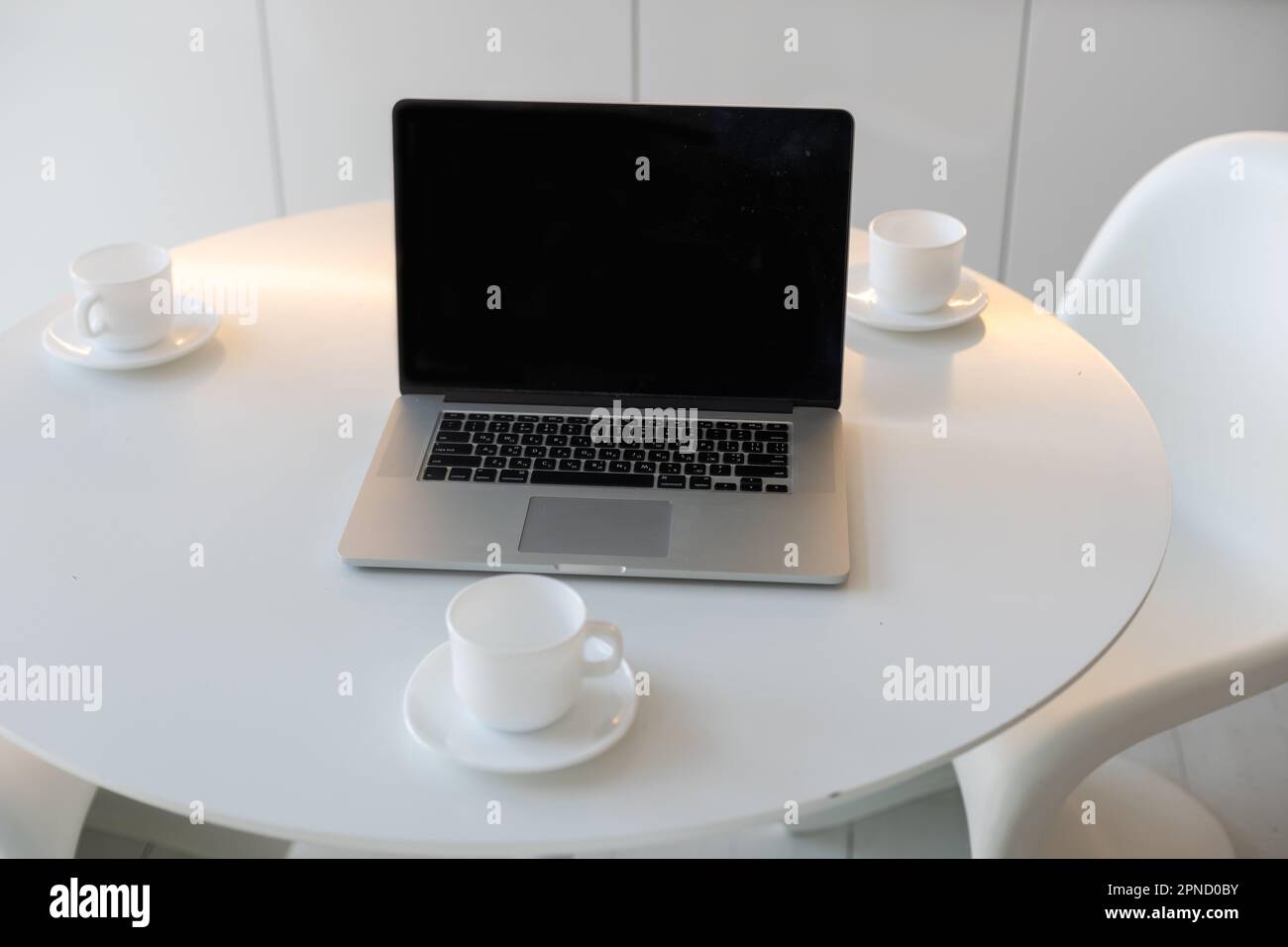 laptop on table with cups Stock Photo - Alamy