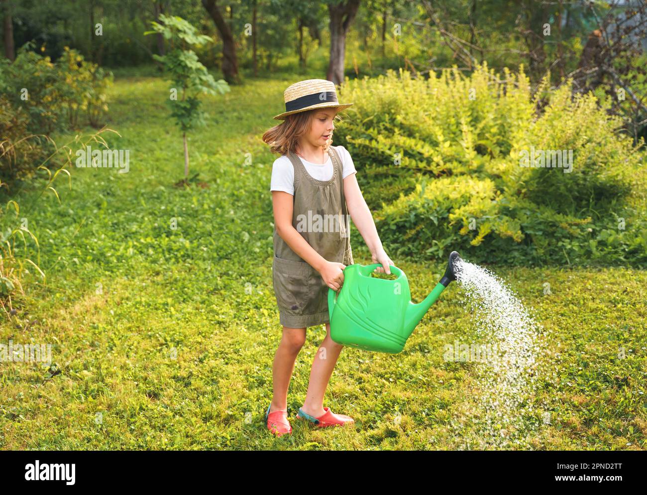 Farmer girl in summer straw hat. Little gardener farming spinning ...