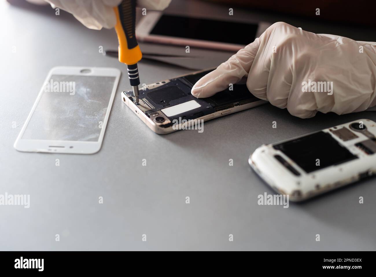 The technician repairing the smartphone's motherboard in the lab with ...