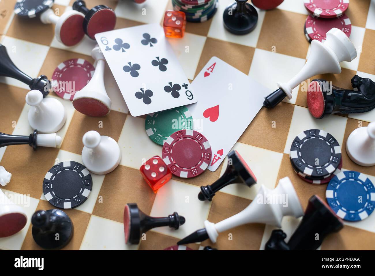 Wooden checkers, chess pieces, playing cards, board games on a light ...
