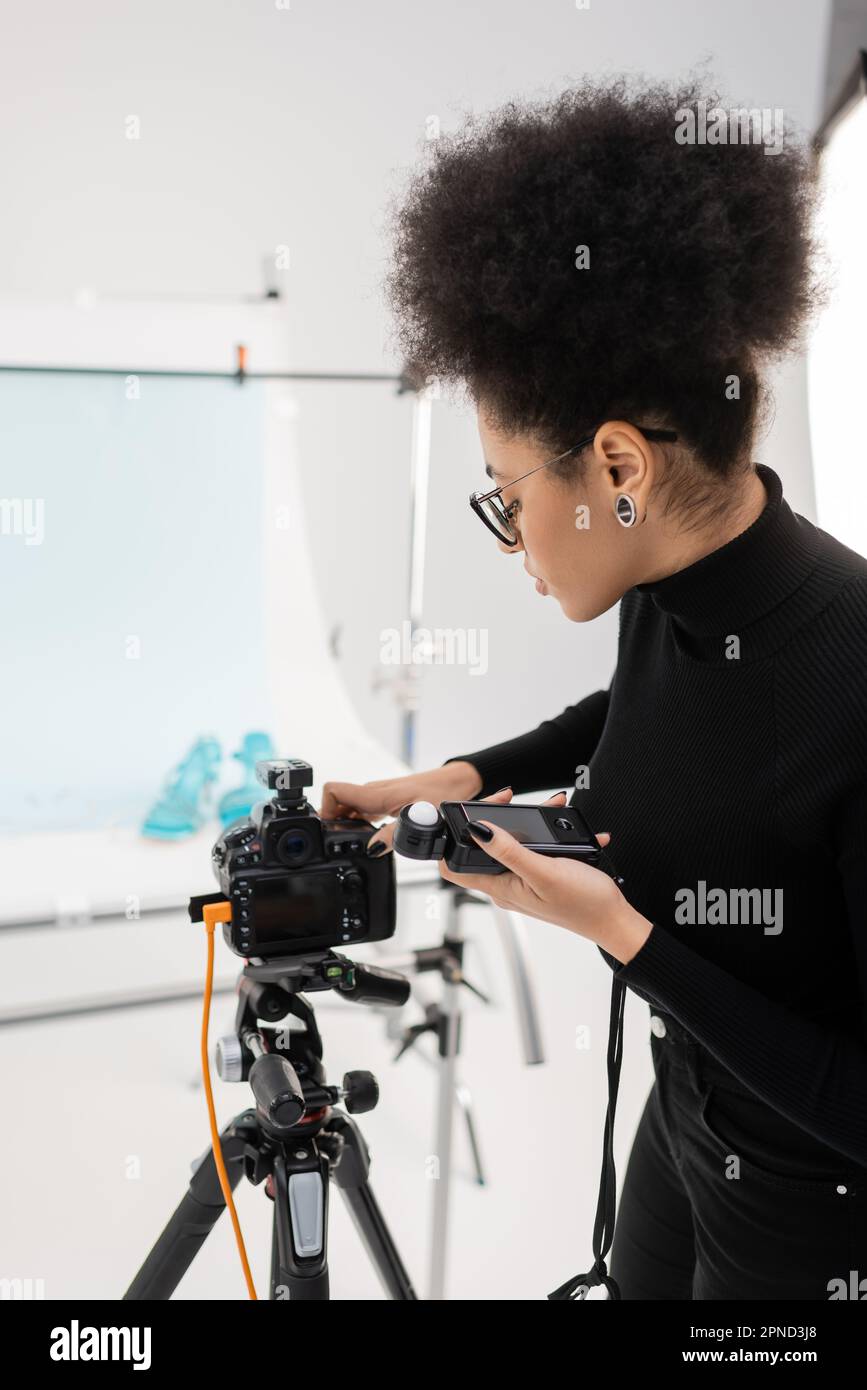 side view of african american content producer with exposure meter ...