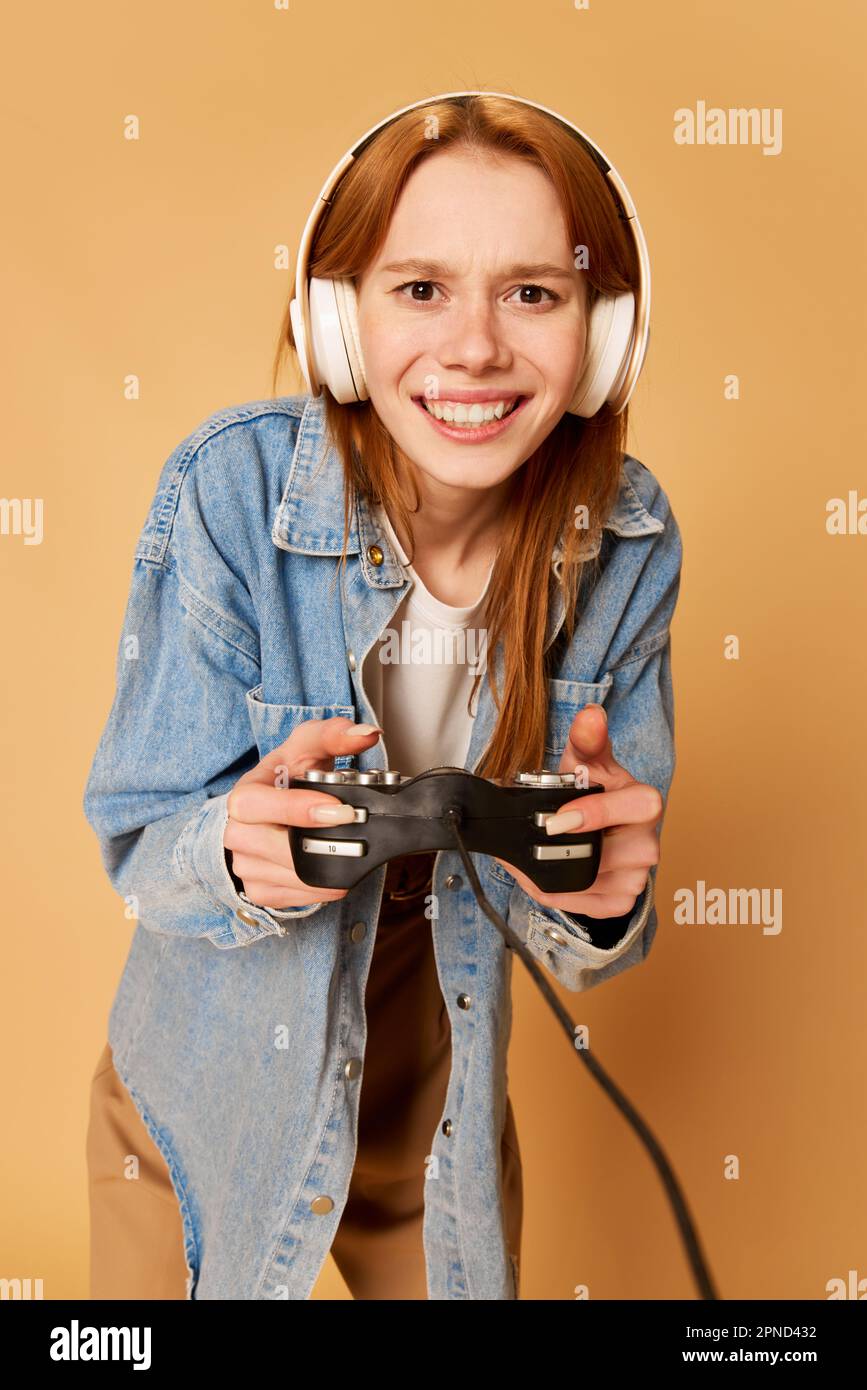 Portrait of young concentrated girl, teenager wearing headphones and ...