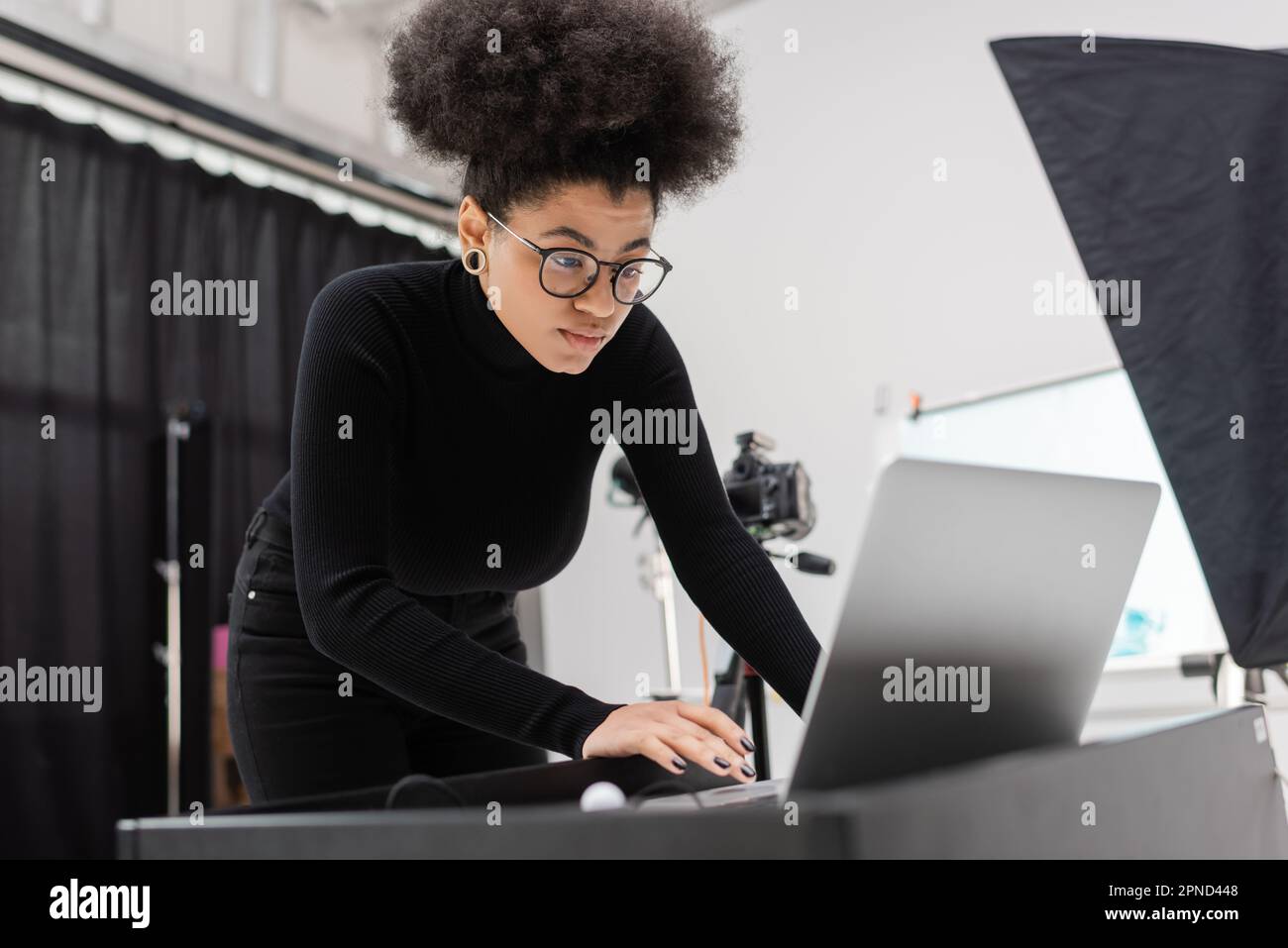 concentrated african american content producer using laptop in photo ...