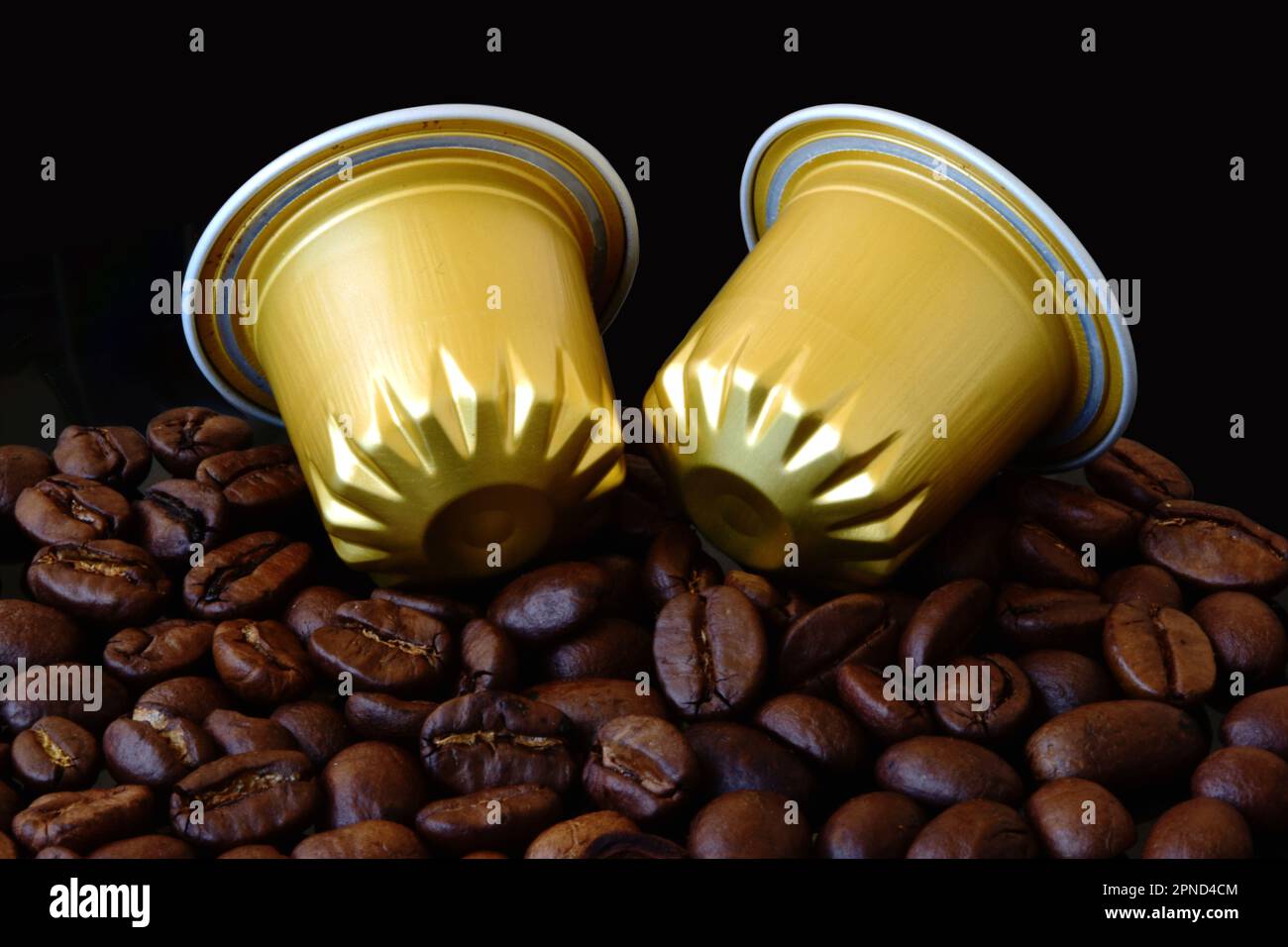 color aluminum coffee capsules on grey glass surface. abstract view ...