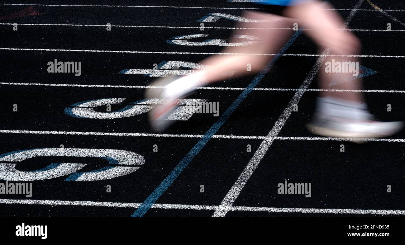 Runner crossing the finish line of a race on a track blurred running fast Stock Photo - Alamy
