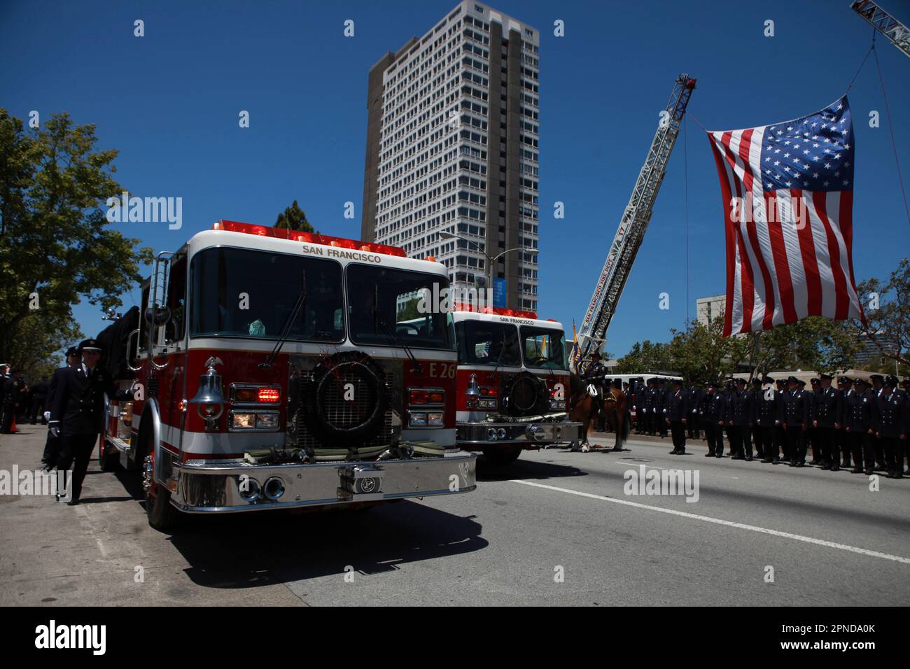 Firefighters walk alongside the two fire engines carrying the caskets ...