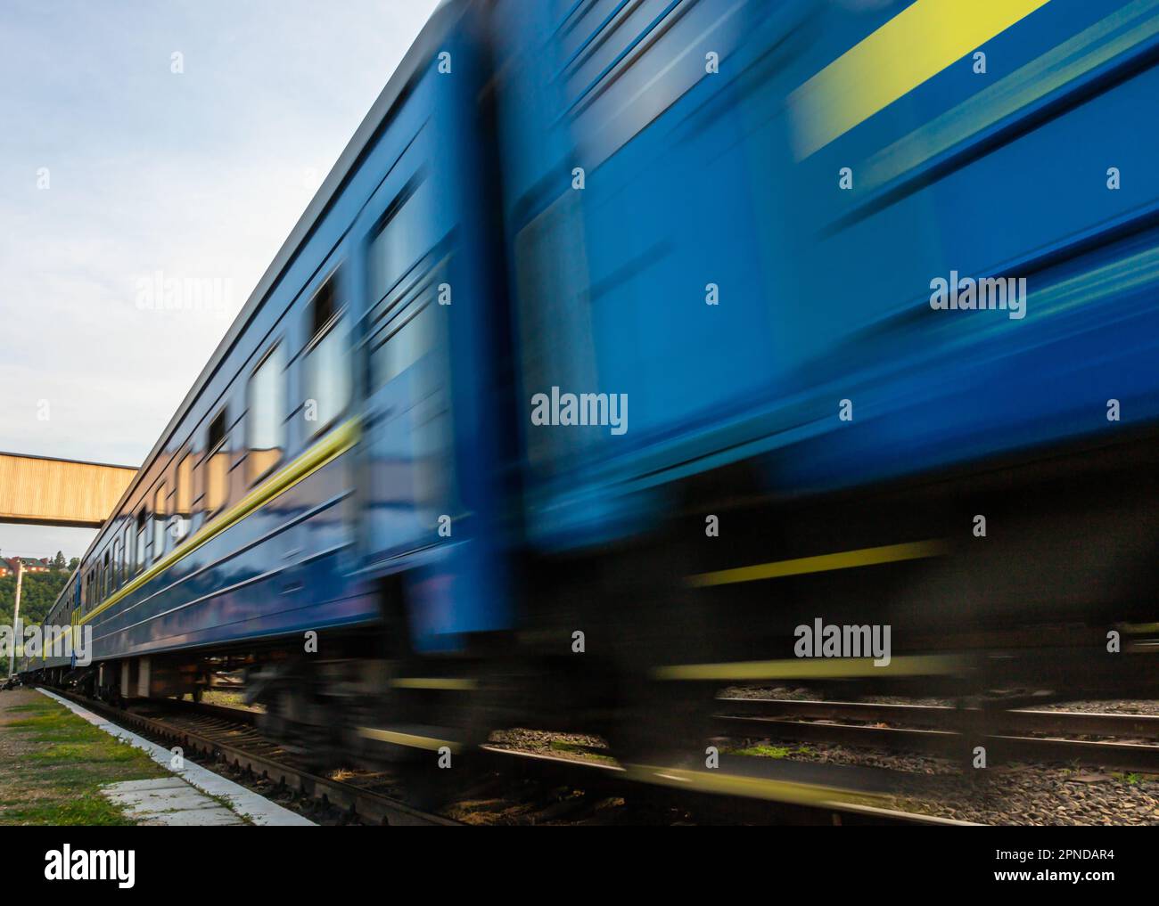 a blue passenger train travels along the track Stock Photo - Alamy