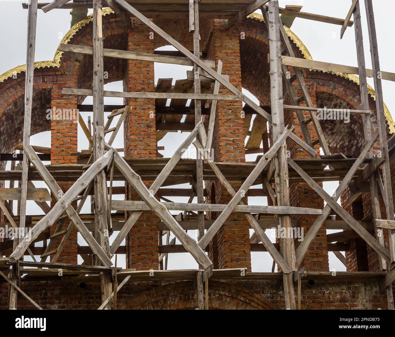 construction of a bell tower and a church. Brick wall. Wooden ...