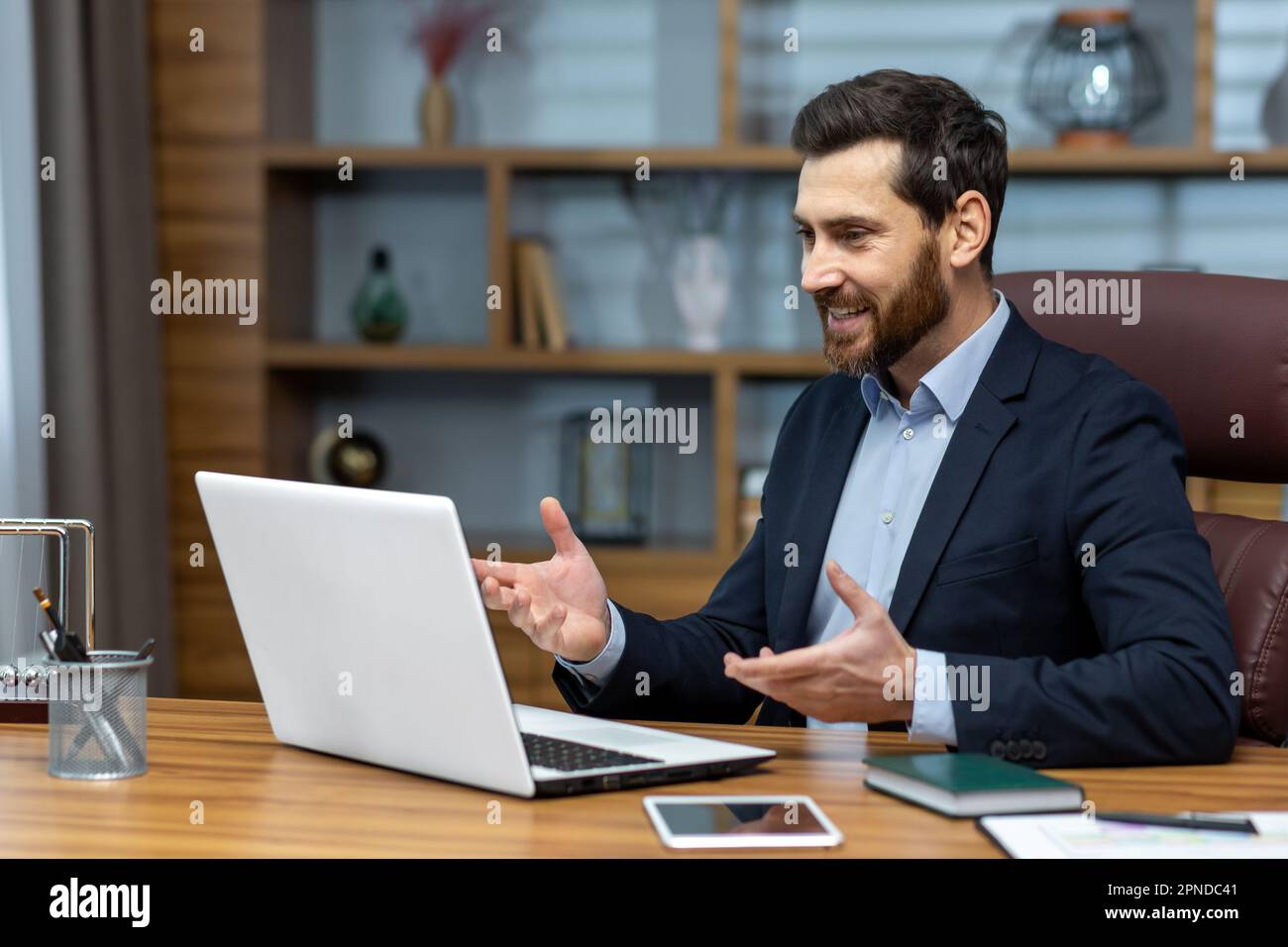 Successful smiling boss talking on video call, man in business suit ...
