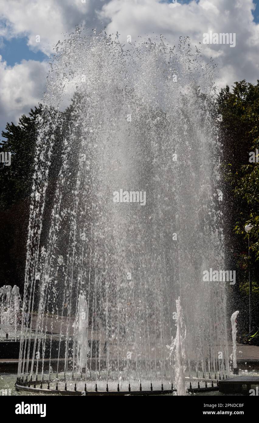 Close up outdoor view in the night of a public fountain with many small ...