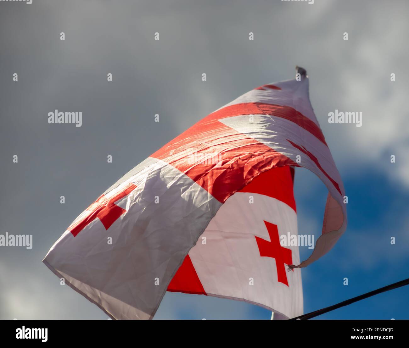 Georgia national flag cloth fabric waving on the sky with beautiful sun ...