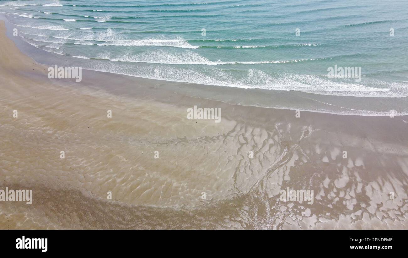 Wet coastal sand and sea waves, top view. Sandy beach and ocean tide ...