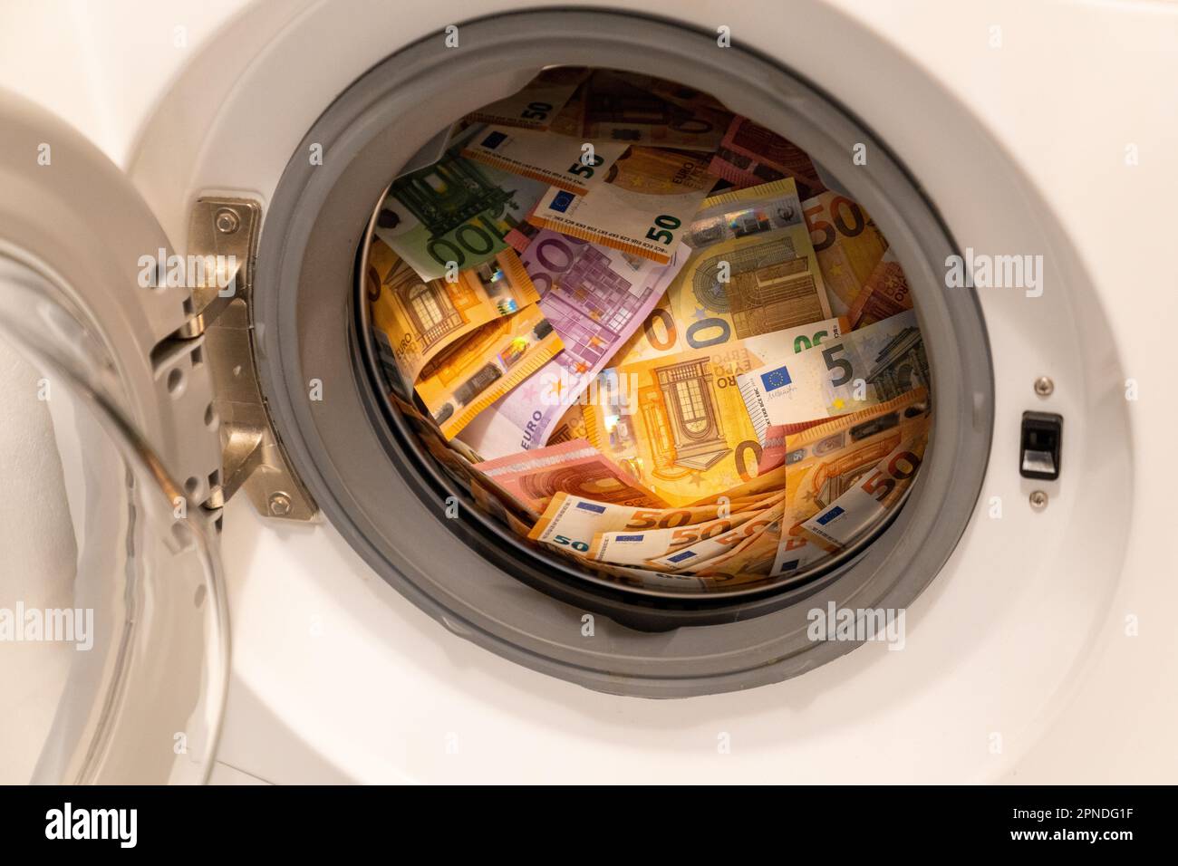 Closeup of a big pile of money in an open washing machine. Money ...