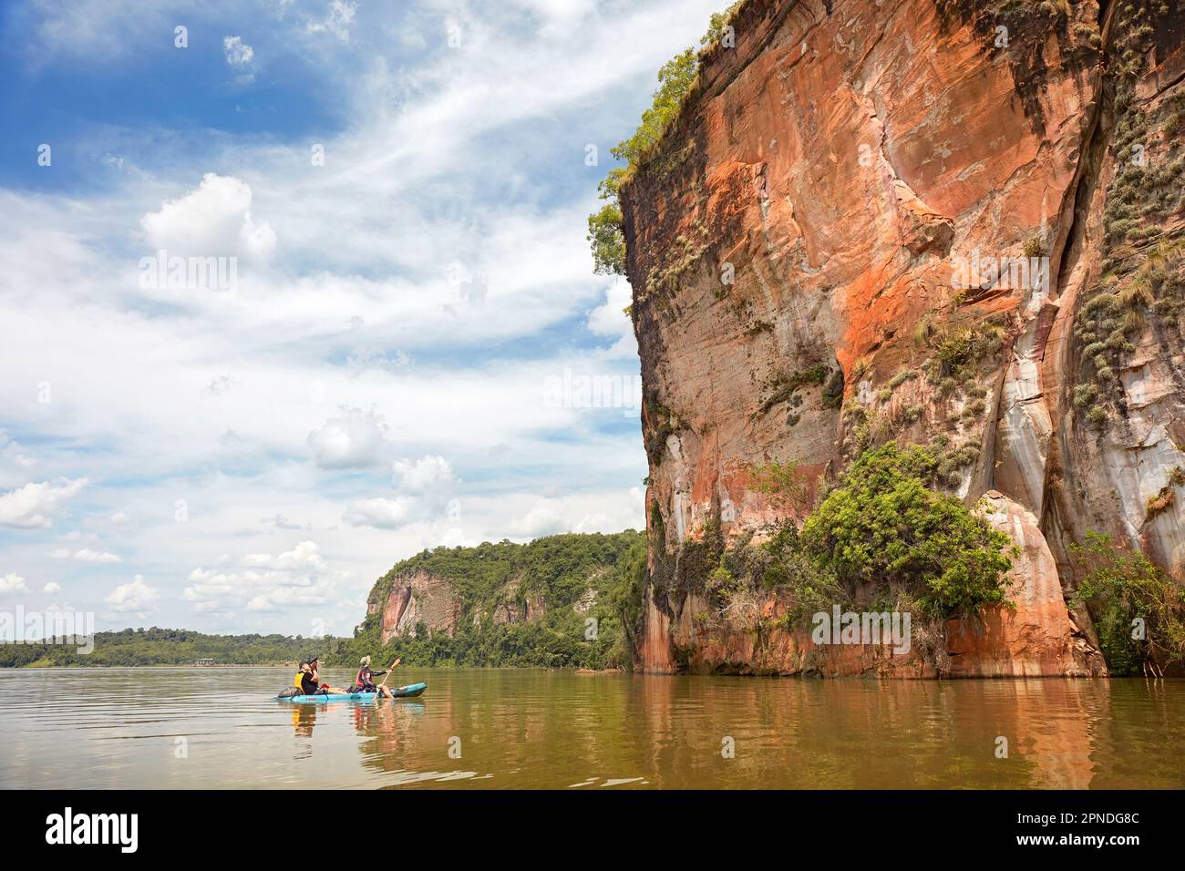 Two people on a kayak in front of the imposing cliff of the Teyú Cuaré ...