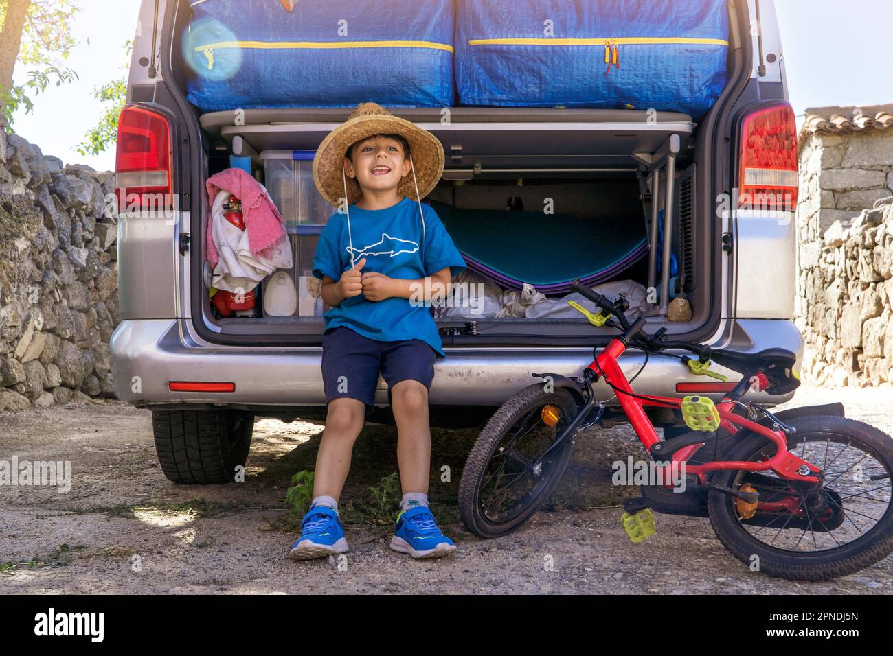 kid with straw hat and bike on a camper van door Stock Photo - Alamy