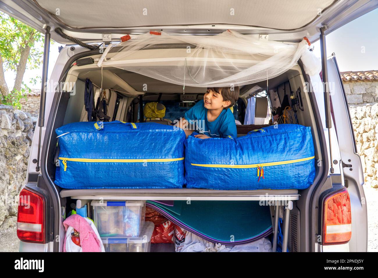 kid in a camper van over the luggage Stock Photo - Alamy