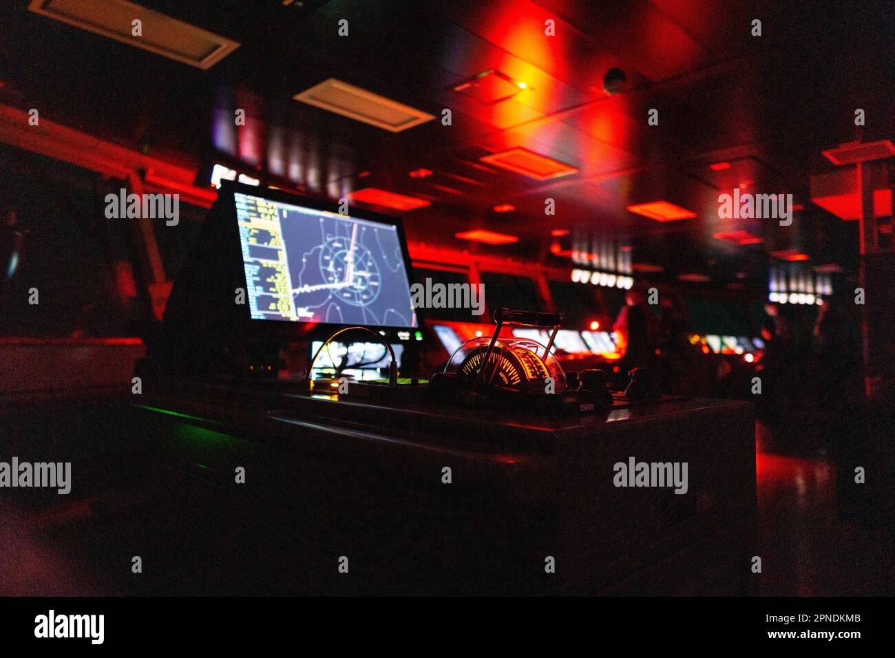 Royal Canadian Navy sailors working on the bridge under red light ...