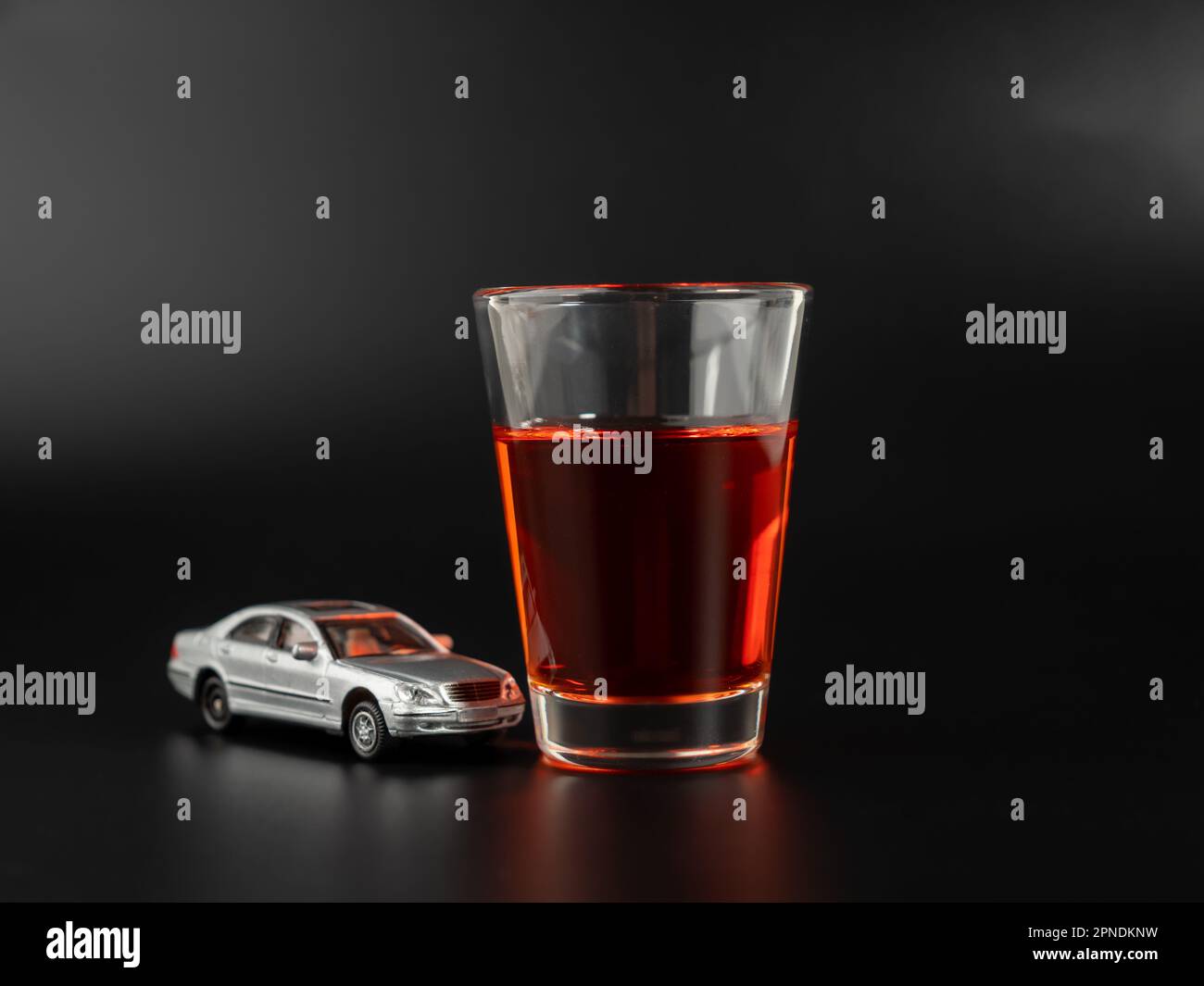 Mini car accident. Alcohol and a toy car on a black background. Drunk ...