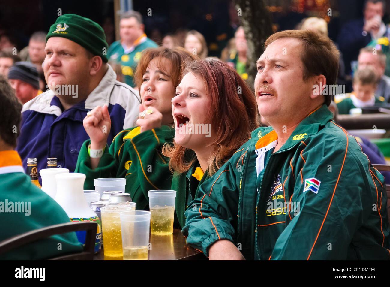 A group of friends having a drink while cheering on their rugby team ...