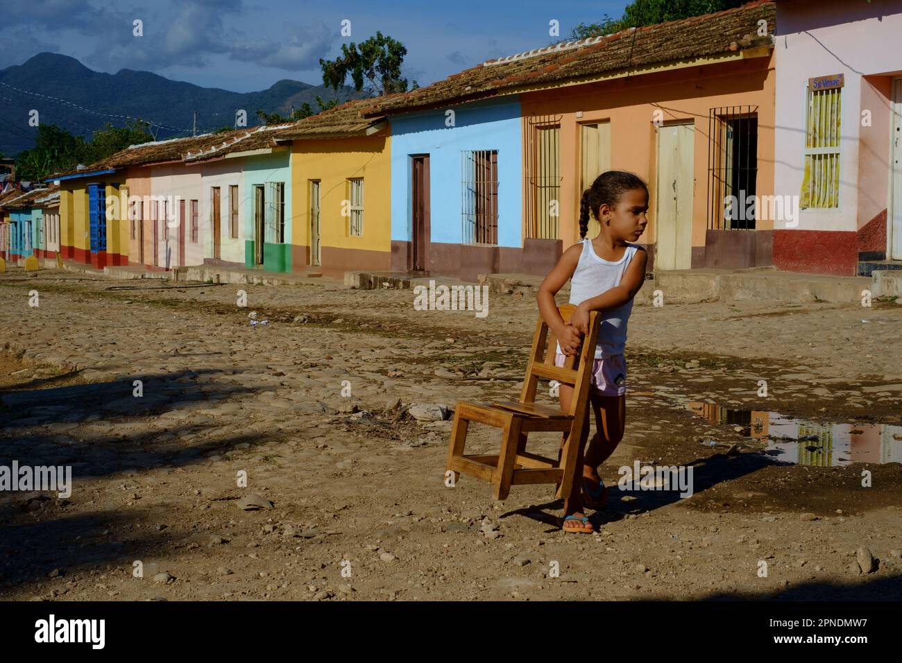 Girl carrying chair, Cuba Stock Photo - Alamy