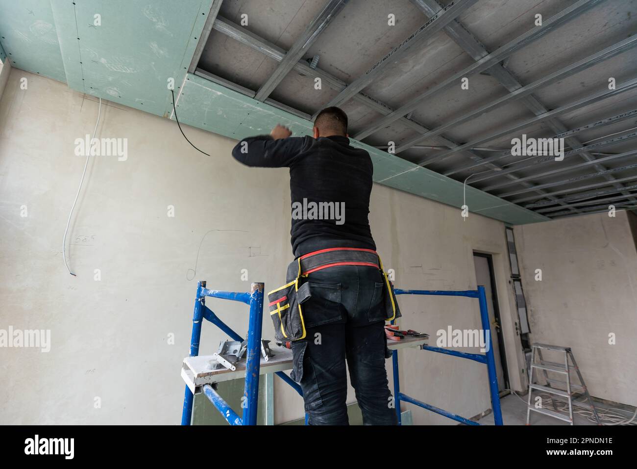Construction worker installation ceiling work Stock Photo - Alamy