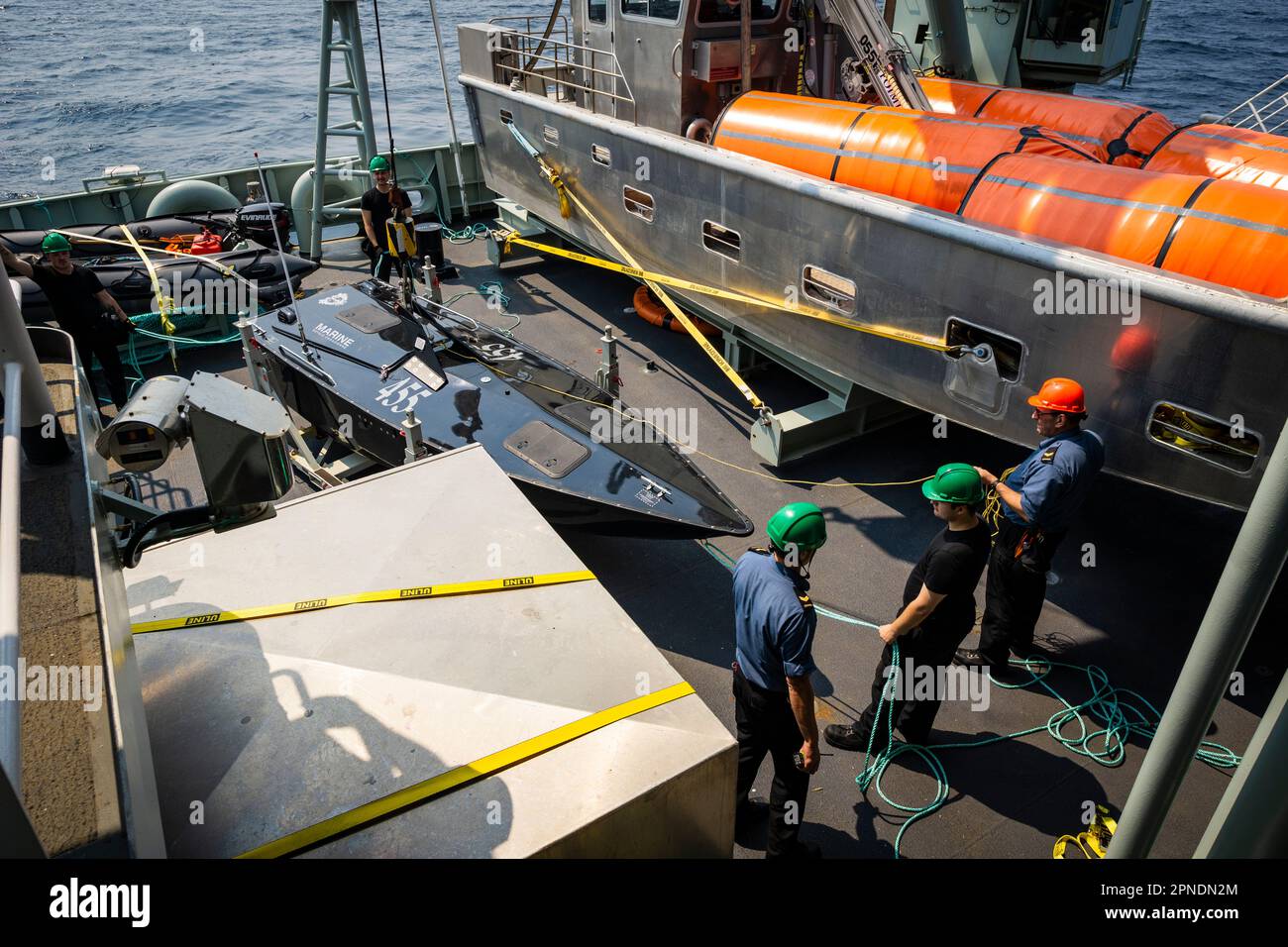 Royal Canadian Navy sailors crane a Meggitt Hammerhead drone into the ...