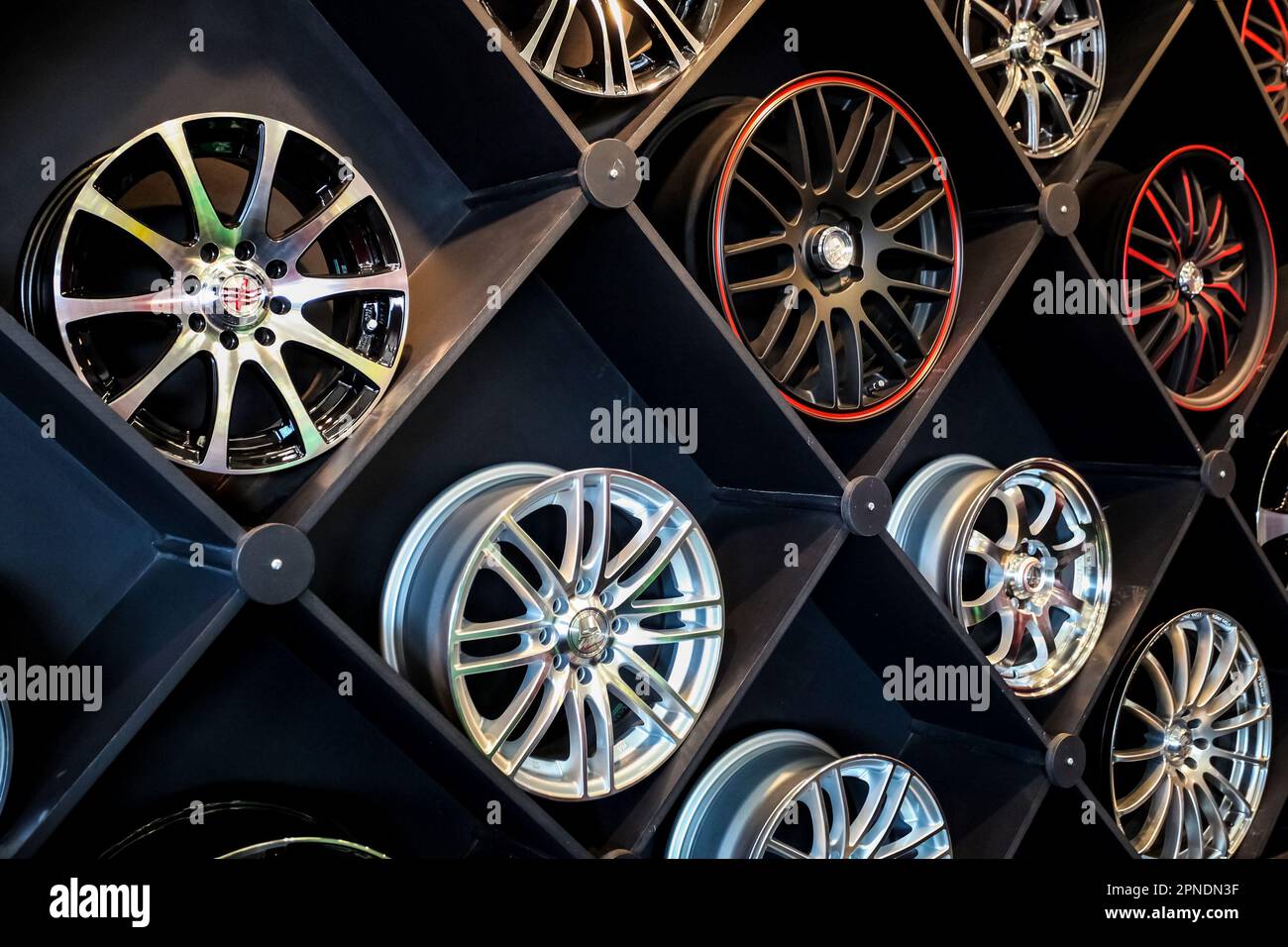 Shiny car rims arranged on a wall in an aesthetic display, ready for ...