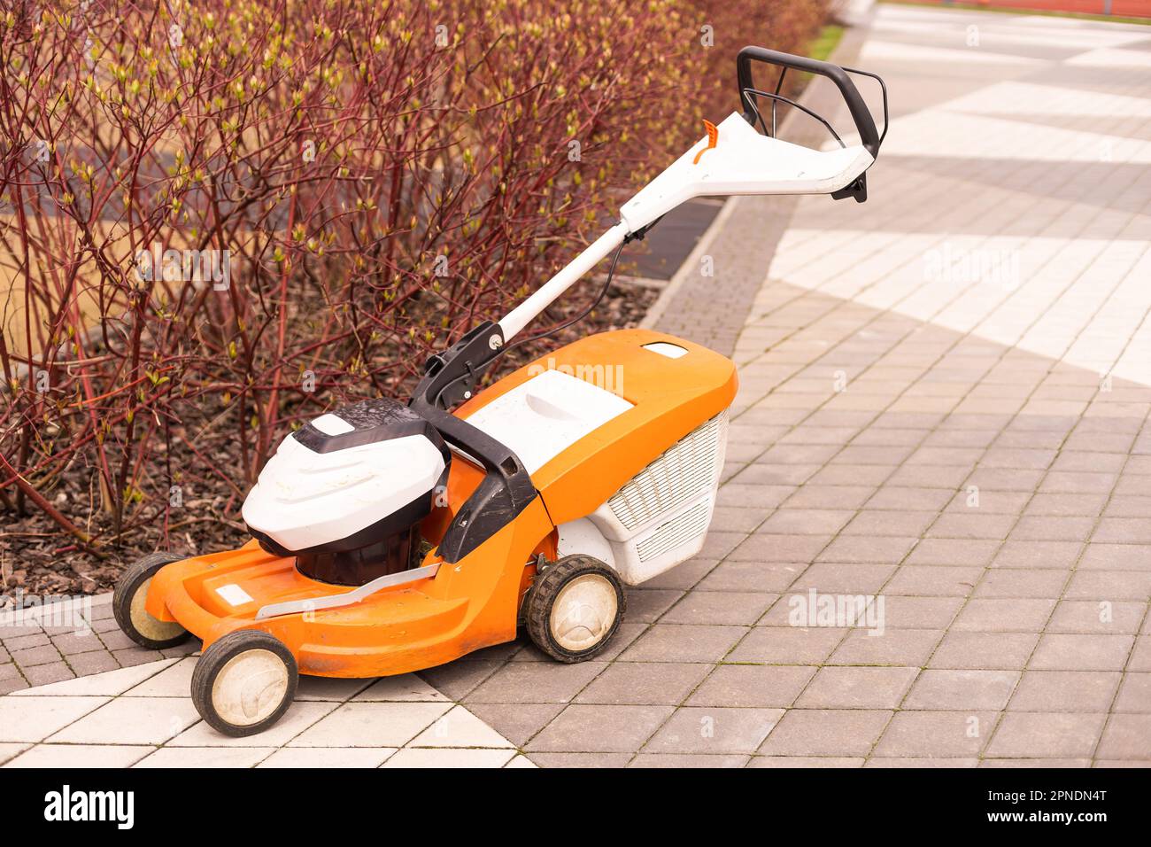 Automatic lawnmower in modern garden Stock Photo - Alamy