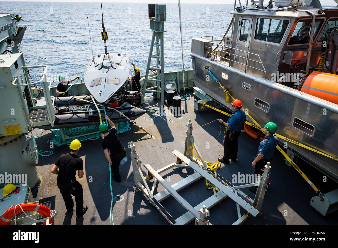 Royal Canadian Navy sailors crane a Meggitt Hammerhead drone into the ...