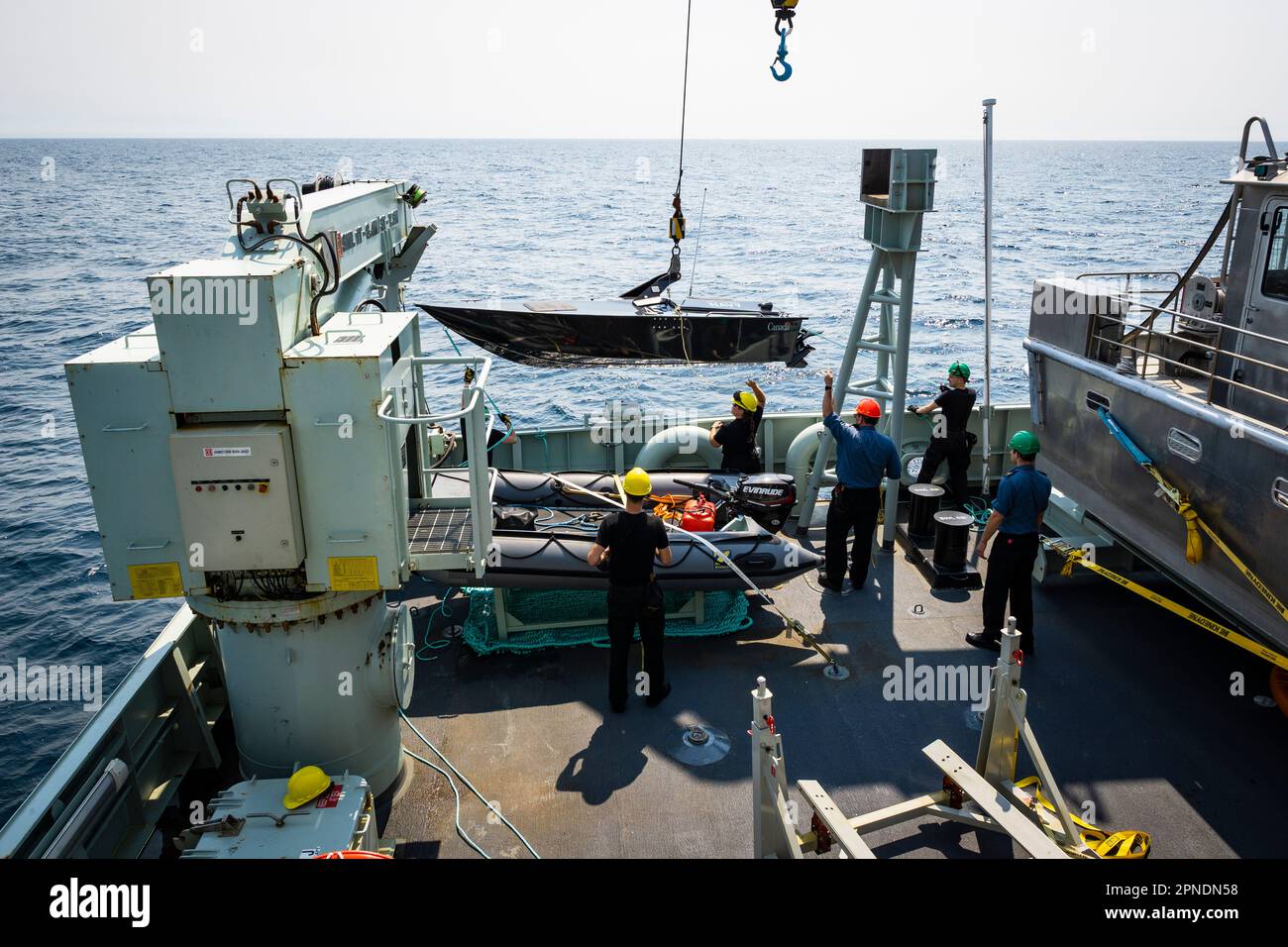Royal Canadian Navy sailors crane a Meggitt Hammerhead drone into the ...