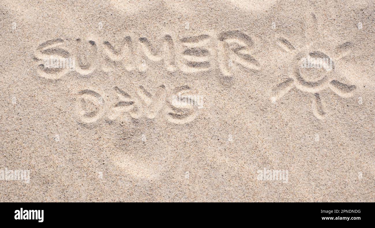 Sand background. Text Summer Days written on sand Stock Photo - Alamy