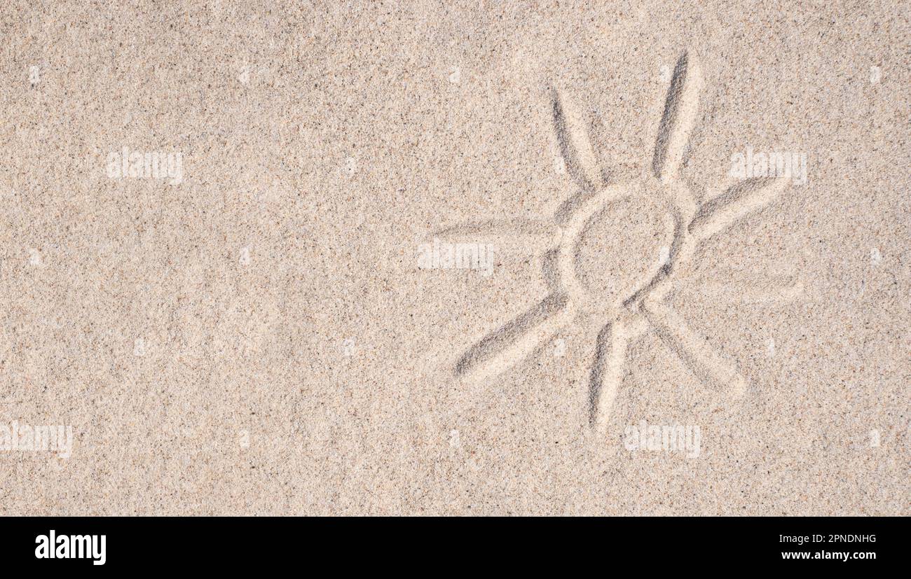 Sand background. Simple image of sun drawn on sand Stock Photo - Alamy