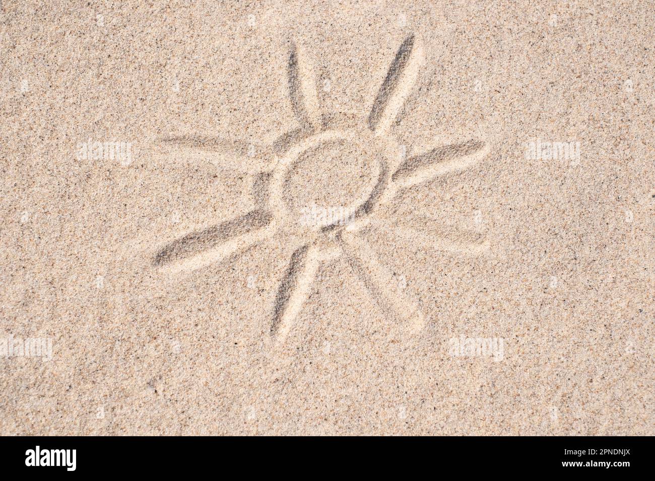 Sand background. Simple image of sun drawn on sand Stock Photo - Alamy