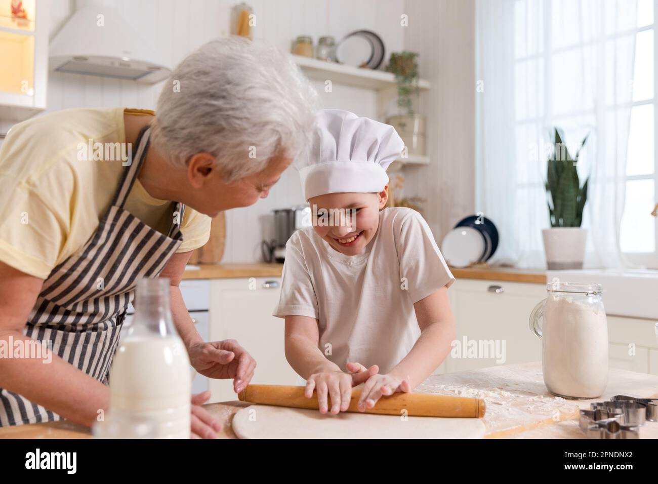 Happy family in kitchen. Grandmother and granddaughter child cook in ...