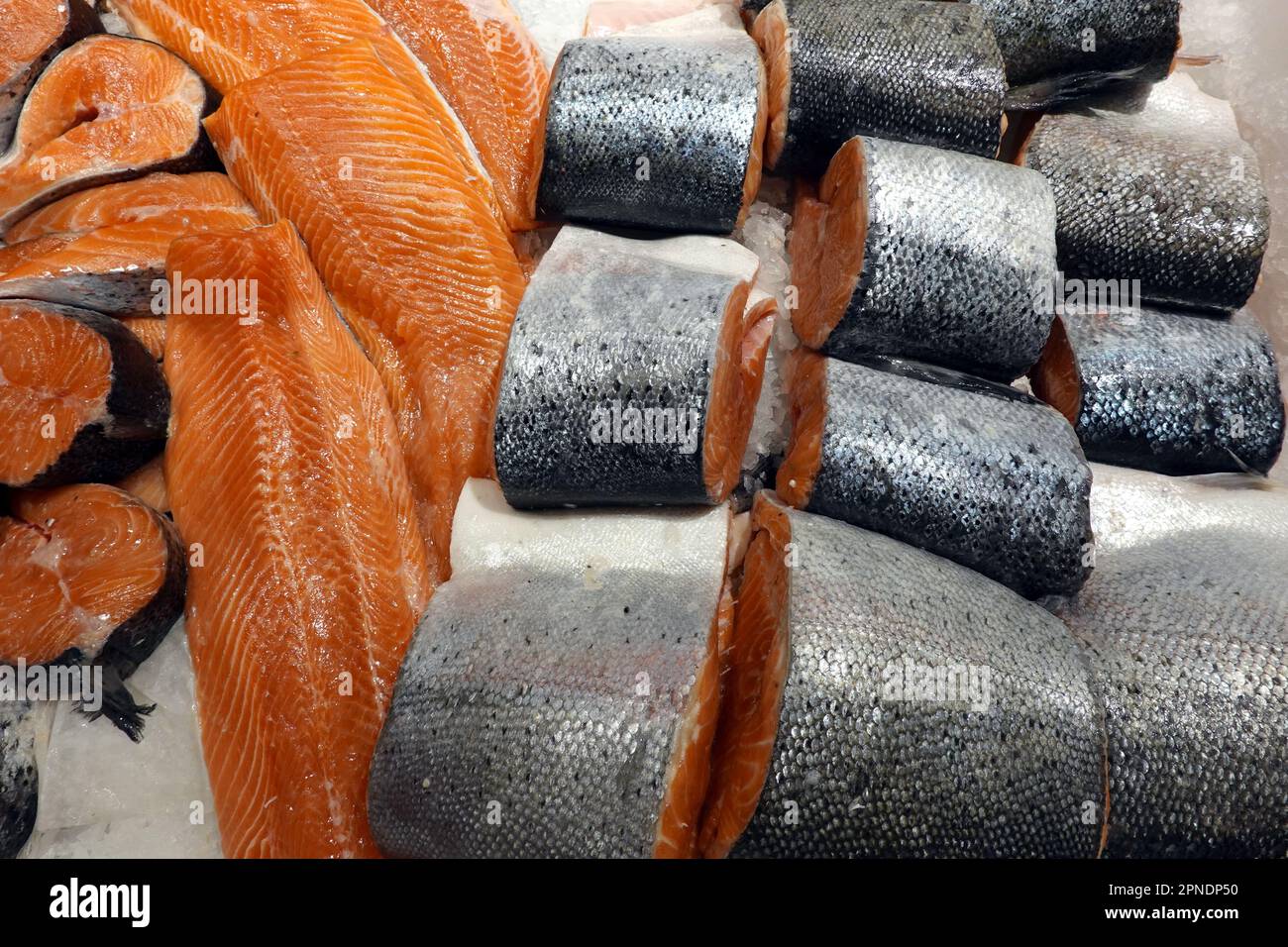 Lot of fresh juicy chilled salmon steaks and red fish pieces with ...