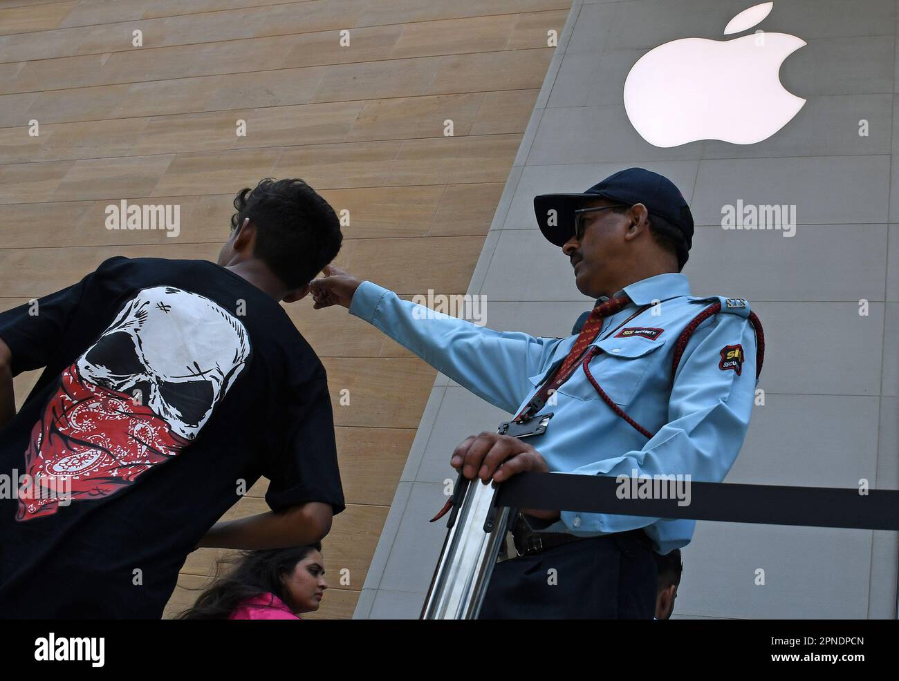 Mumbai, India. 18th Apr, 2023. A security guard directs a man outside ...